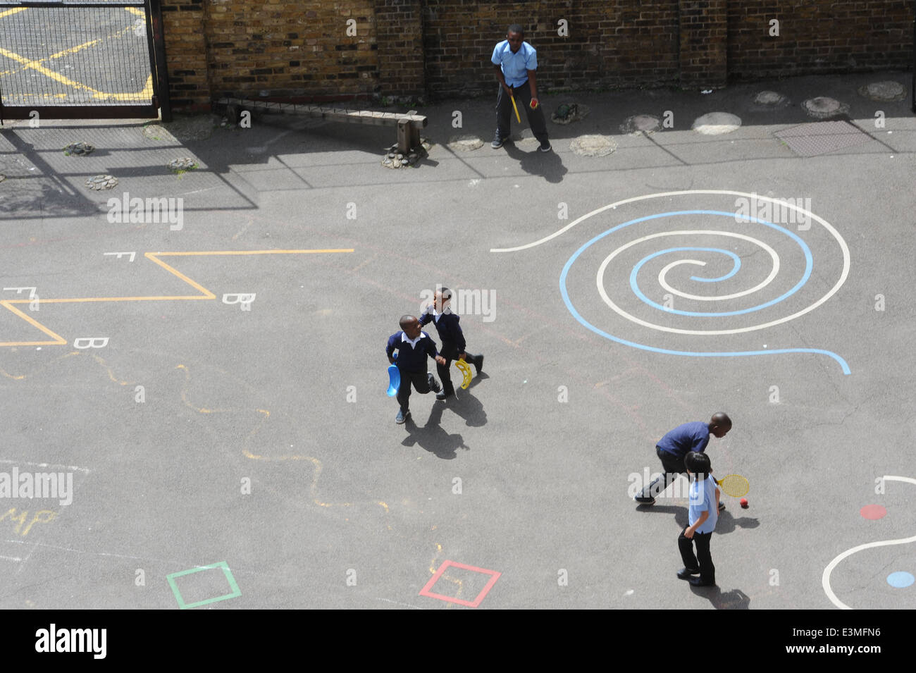 School children playing in a school playground in an inner city london ...