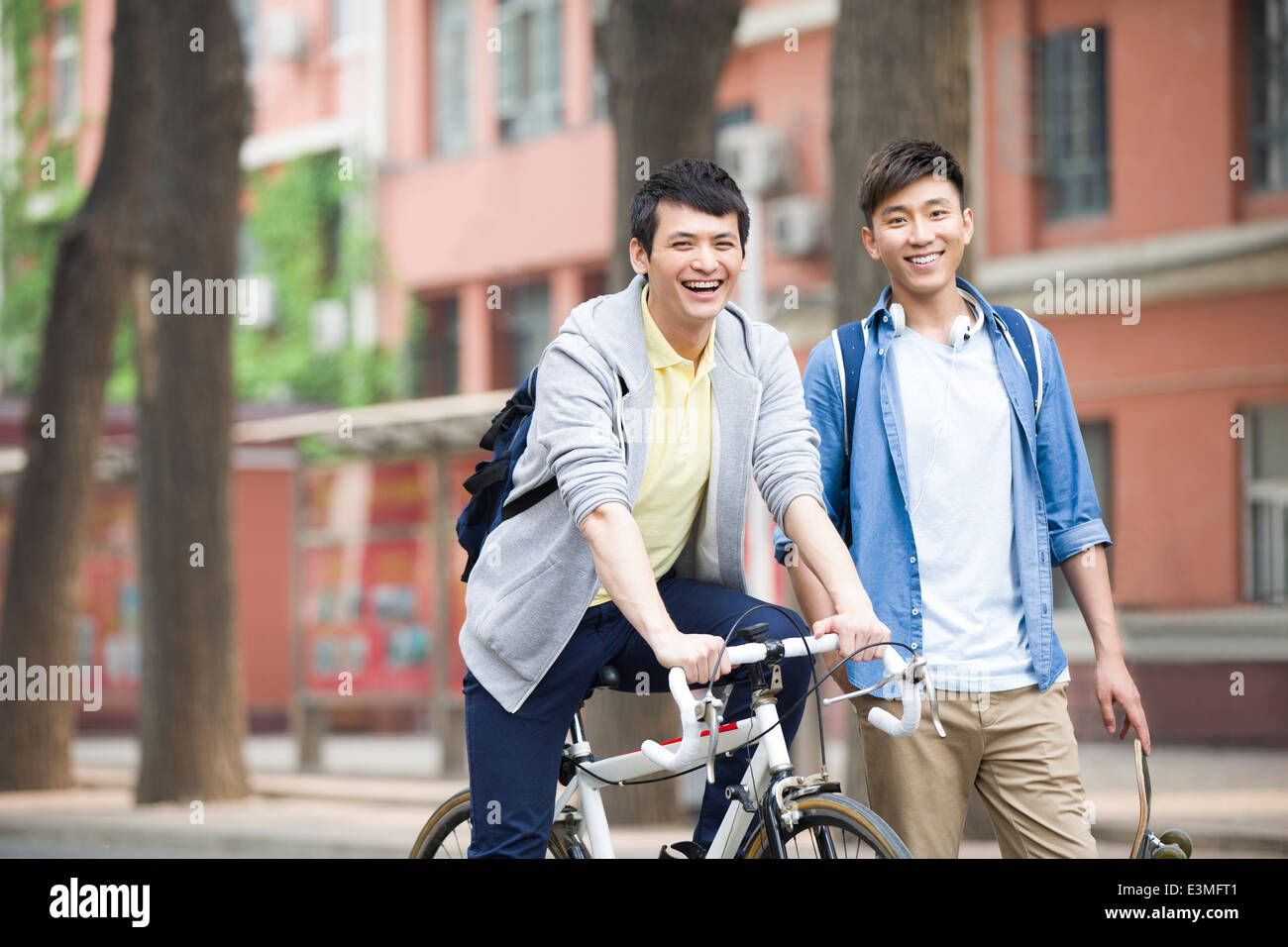 Male college students with bicycle on campus Stock Photo - Alamy
