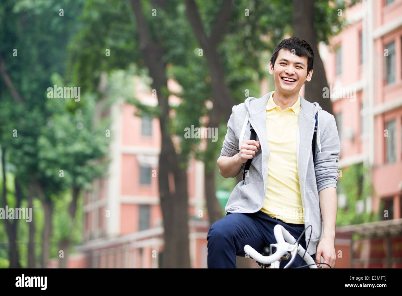 Male college student with bicycle on campus Stock Photo - Alamy