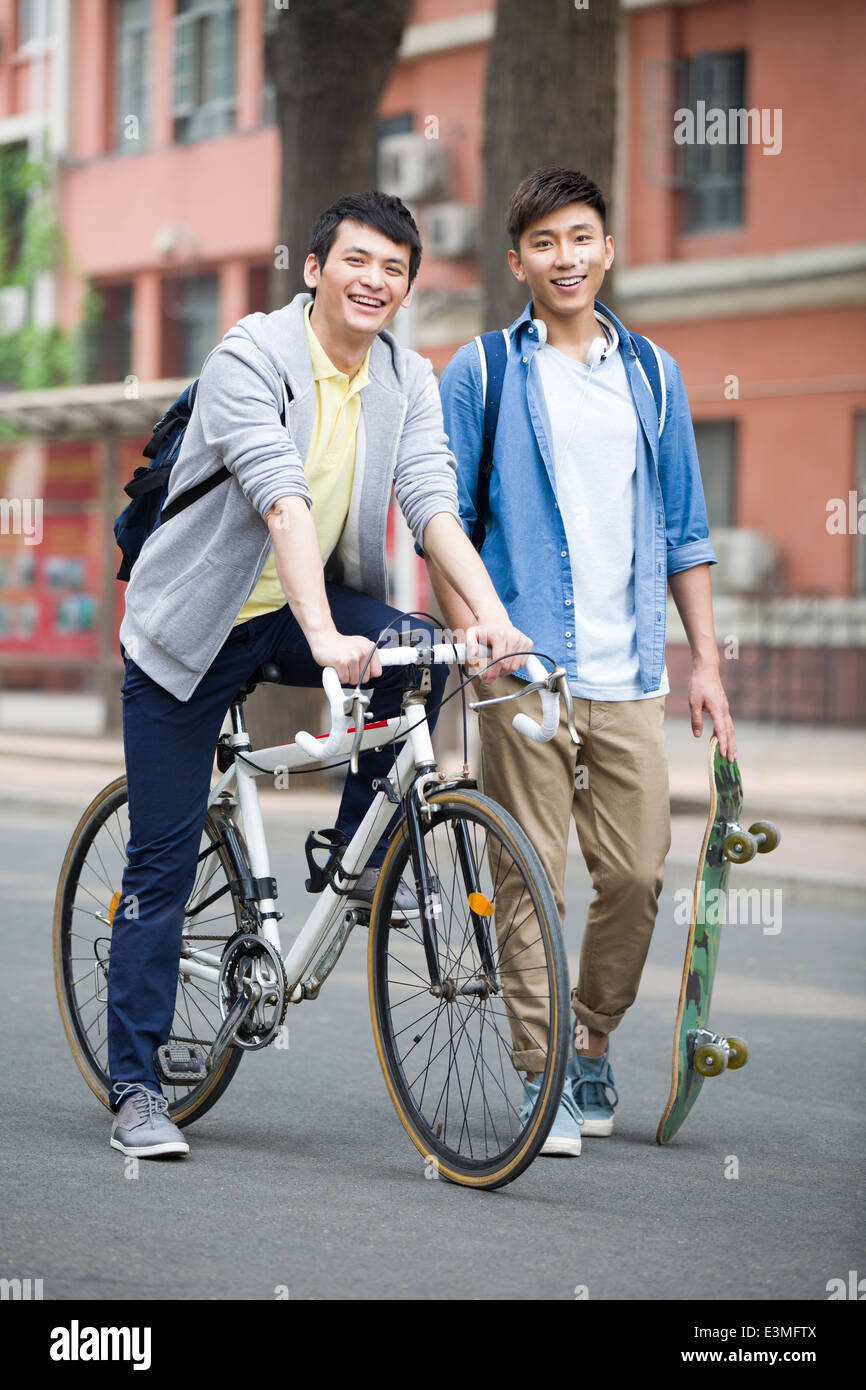 Male college students with bicycle on campus Stock Photo - Alamy