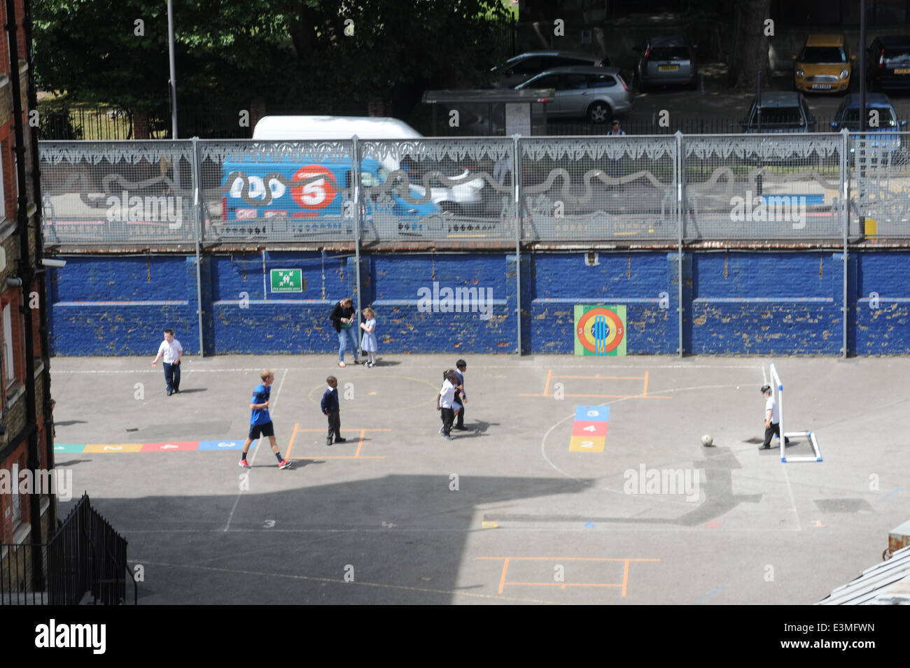 School children playing in a school playground in an inner city london ...