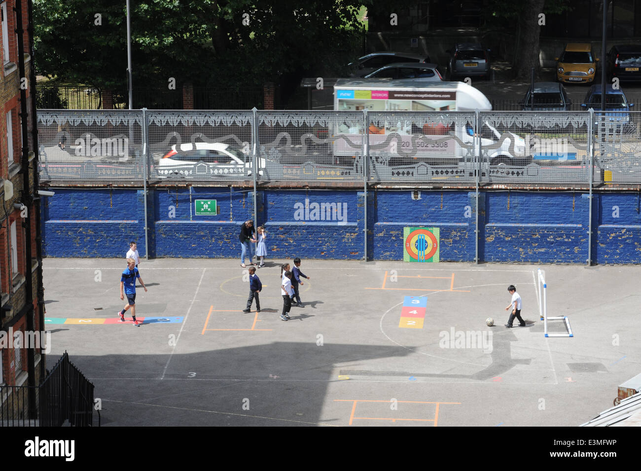 School children playing in a school playground in an inner city london ...