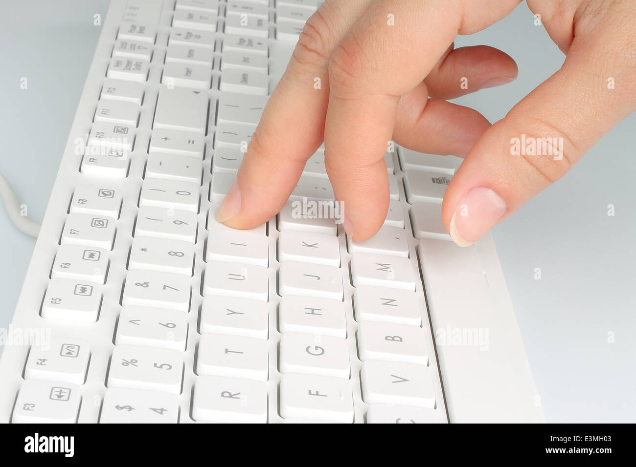 Hand pushing the button of grey keyboard Stock Photo - Alamy