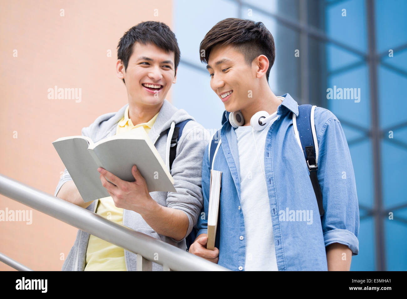 Male college students reading outside library Stock Photo - Alamy