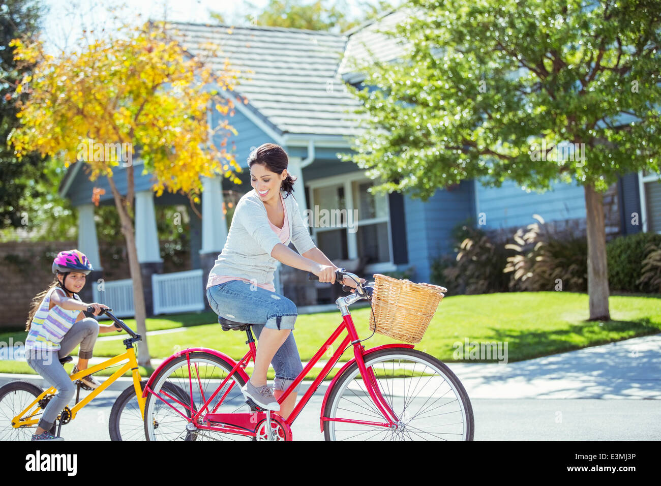 Mother and daughter riding bikes in street Stock Photo - Alamy