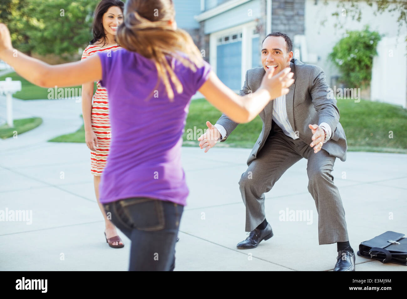 Daughter running to father in driveway Stock Photo - Alamy