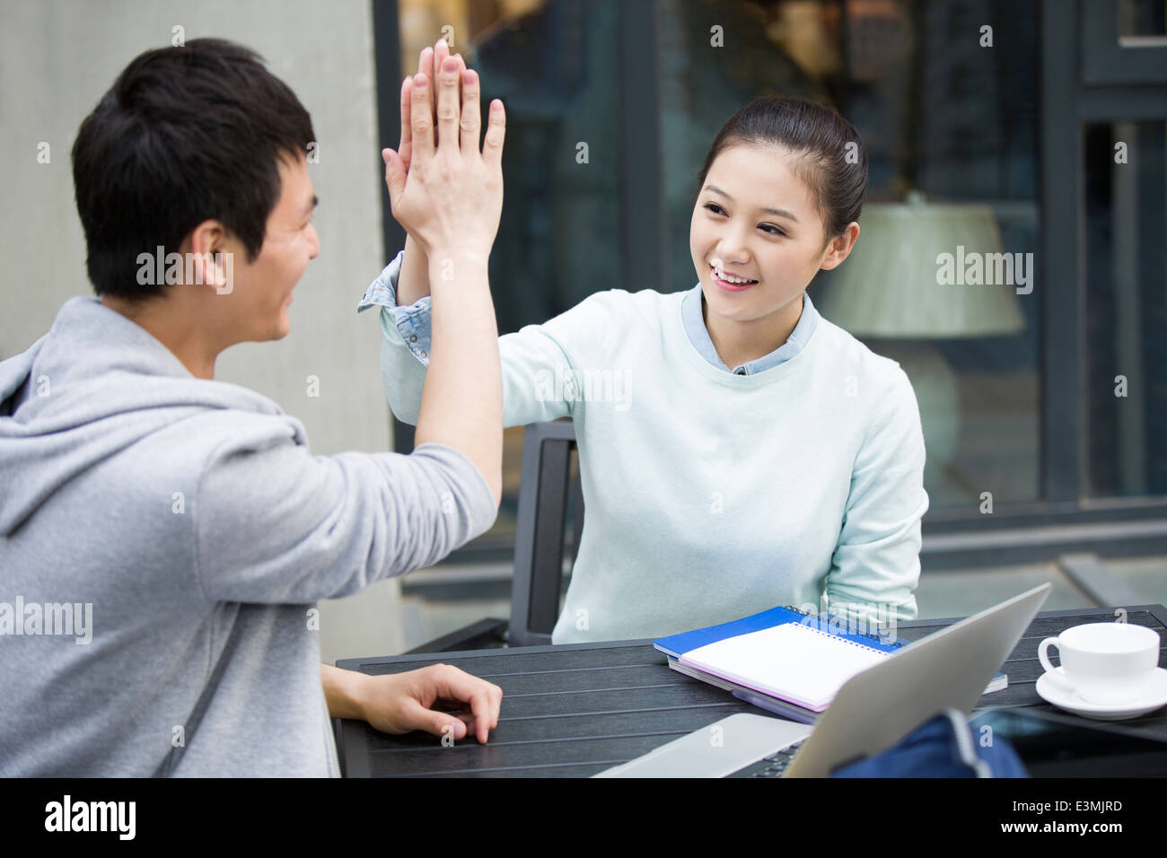 Young couple doing high-five Stock Photo - Alamy