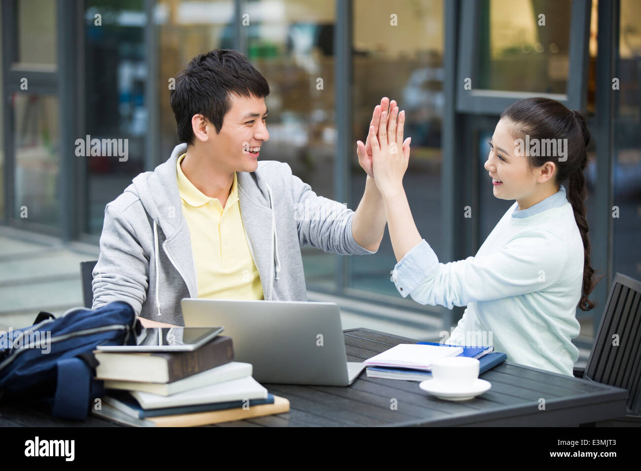 Young couple doing high-five Stock Photo - Alamy