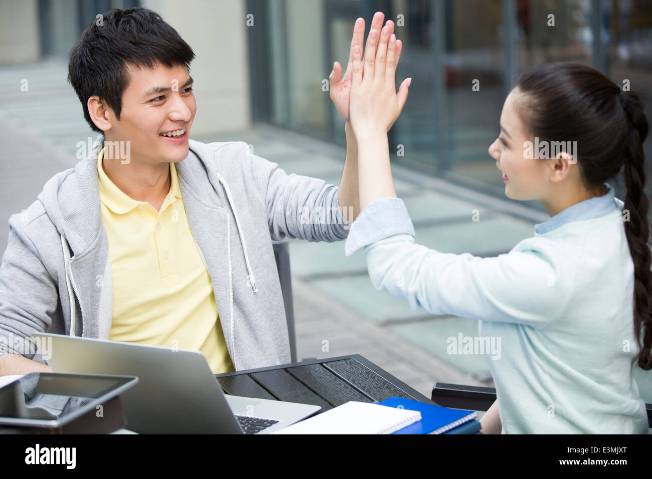 Young couple doing high-five Stock Photo - Alamy