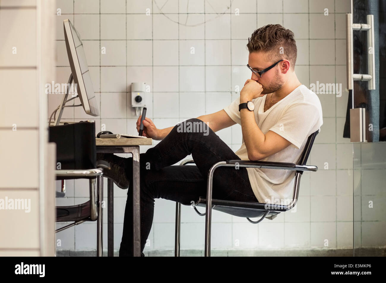 Side view of young businessman at computer desk in new office Stock ...