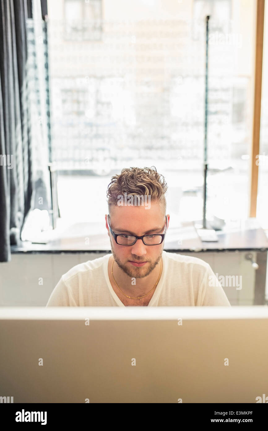 Concentrated young businessman using computer at office desk Stock ...