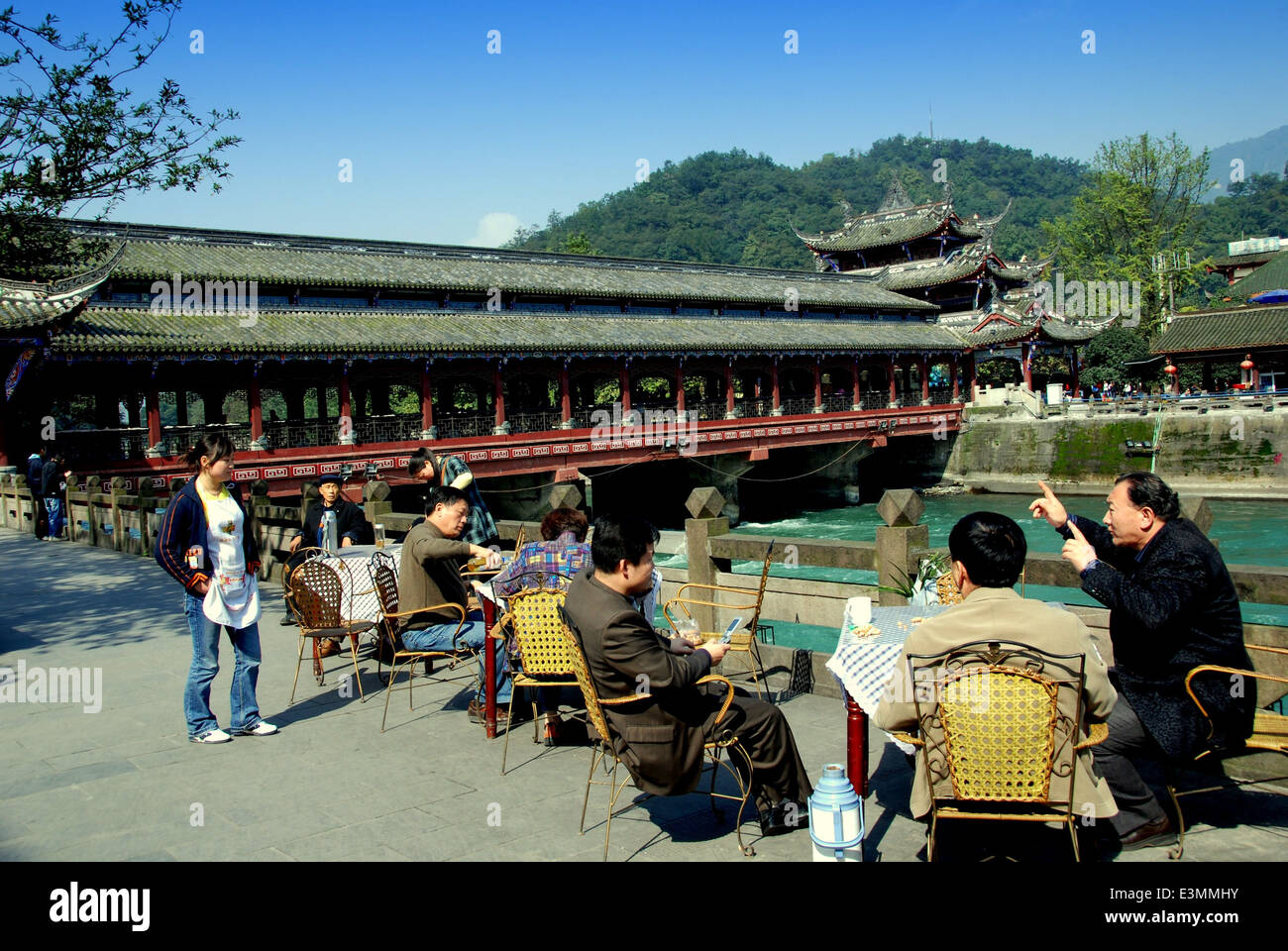 DUJIANGYAN, CHINA: PATRONS AT AN OUTSIDE CAFE OVERLOOKING THE MIN RIVER ...