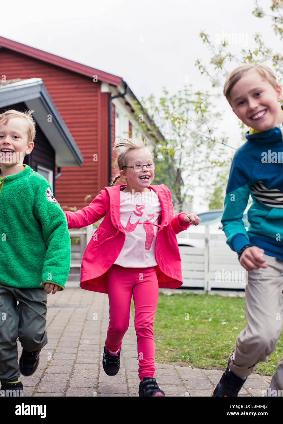 Girl with brothers running in lawn Stock Photo - Alamy