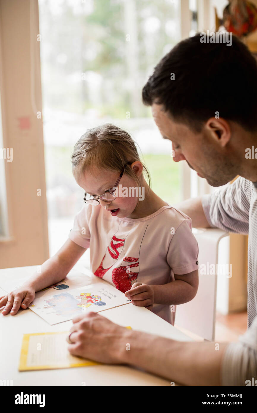 Father assisting handicapped girl in studying at home Stock Photo - Alamy