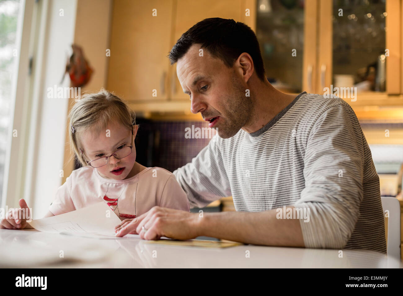 Father assisting handicapped daughter in studying at home Stock Photo ...