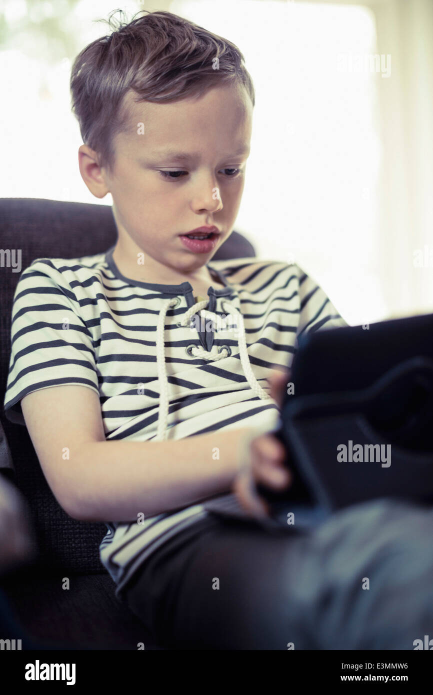 Boy using digital tablet on sofa Stock Photo - Alamy
