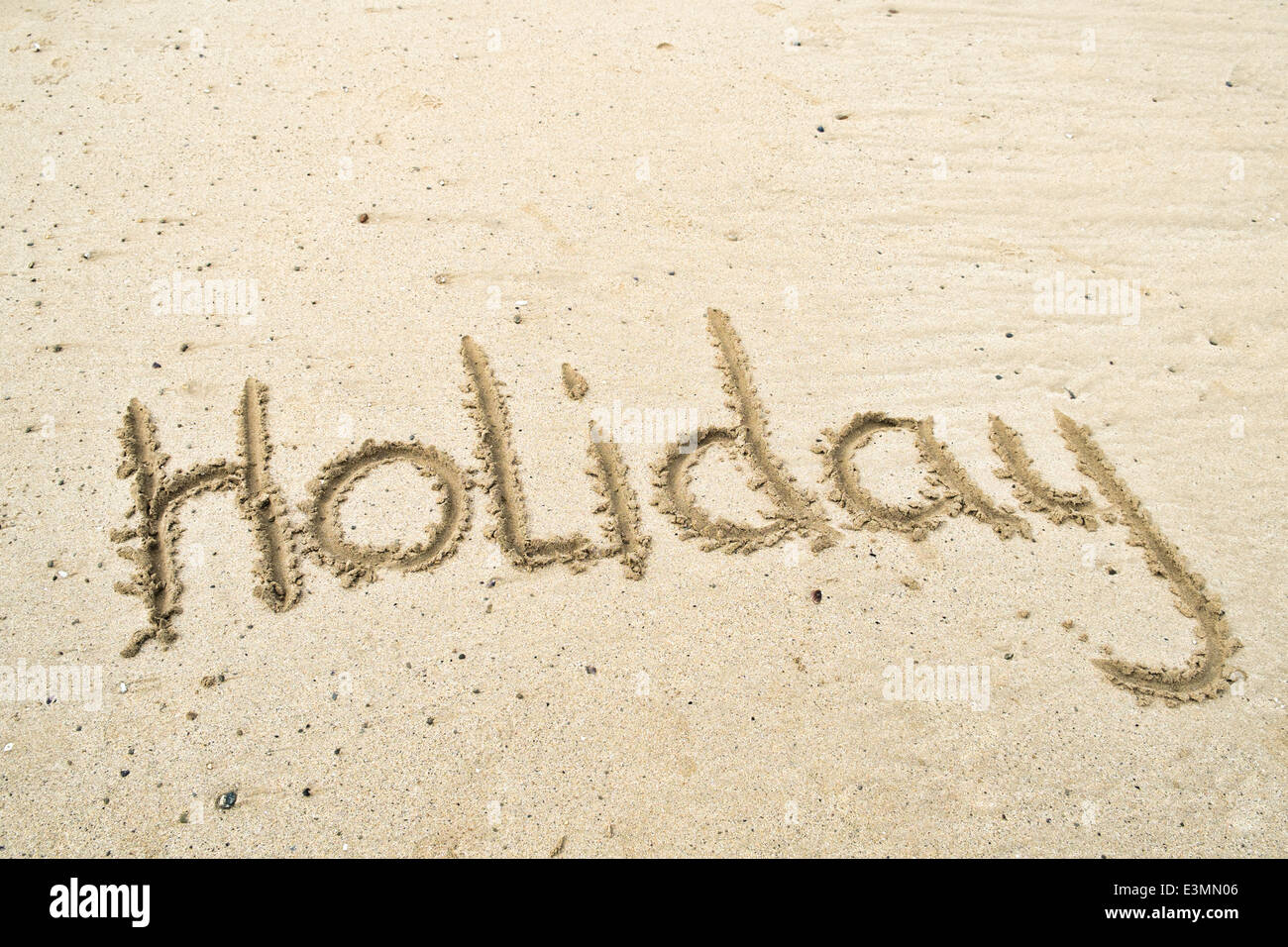 The Word holiday written in sand on a beach Stock Photo - Alamy