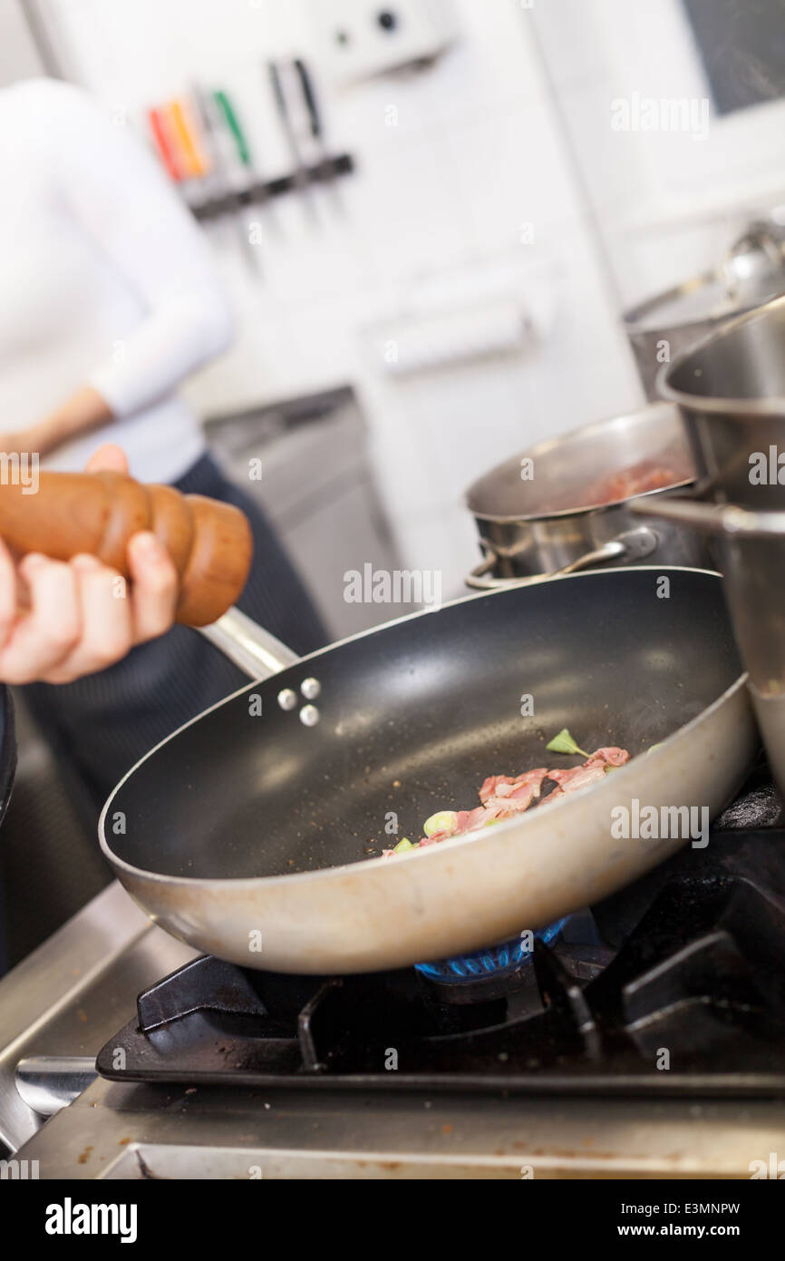 Professional chef in a commercial kitchen cooking a vegetable stir fry ...