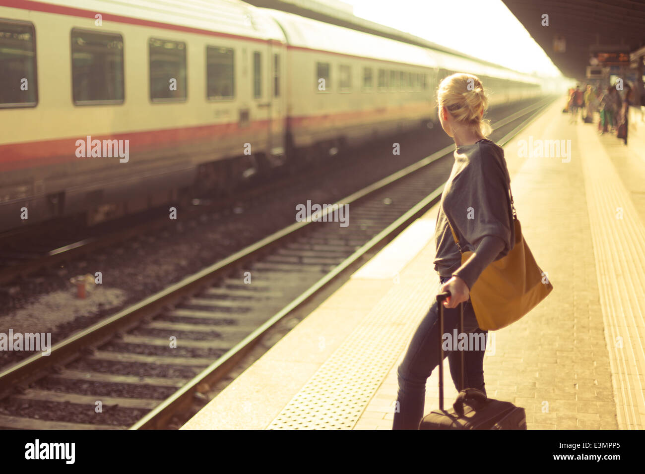 Lady waiting at the railway station Stock Photo - Alamy