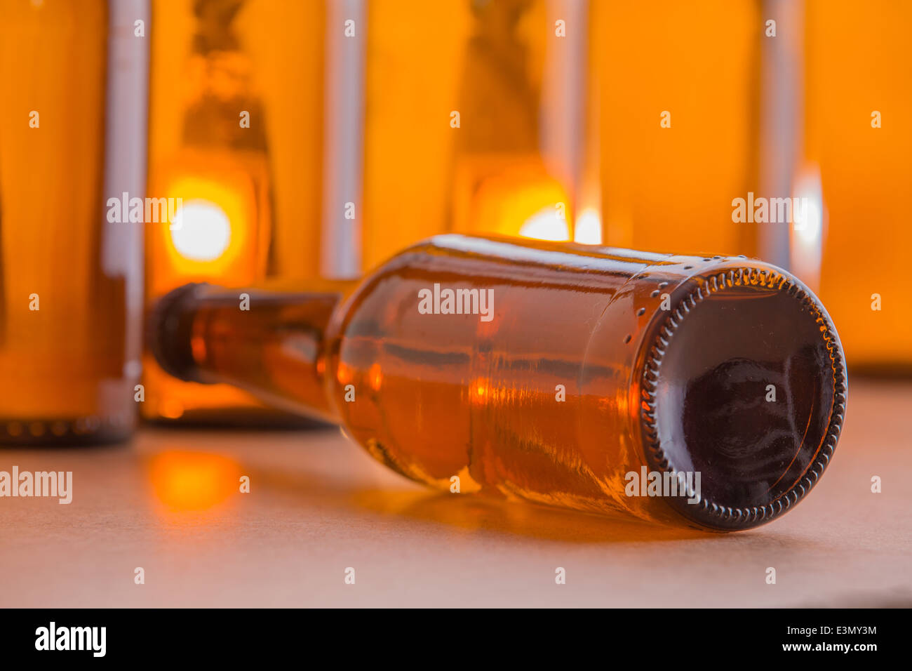 A brown beer bottle lying on it's side with more bottles in the ...