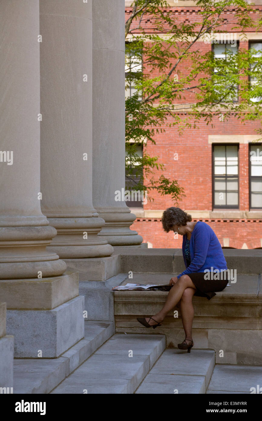 A woman reads between the Roman pillars of the HARRY ELKINS WIDENER ...