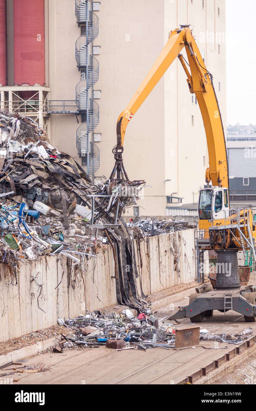 Open barge being loaded or offloaded at a wharf on an urban waterway or ...