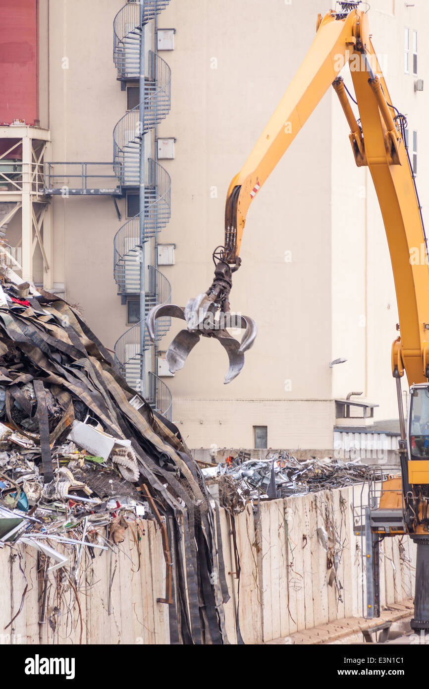 Open barge being loaded or offloaded at a wharf on an urban waterway or ...