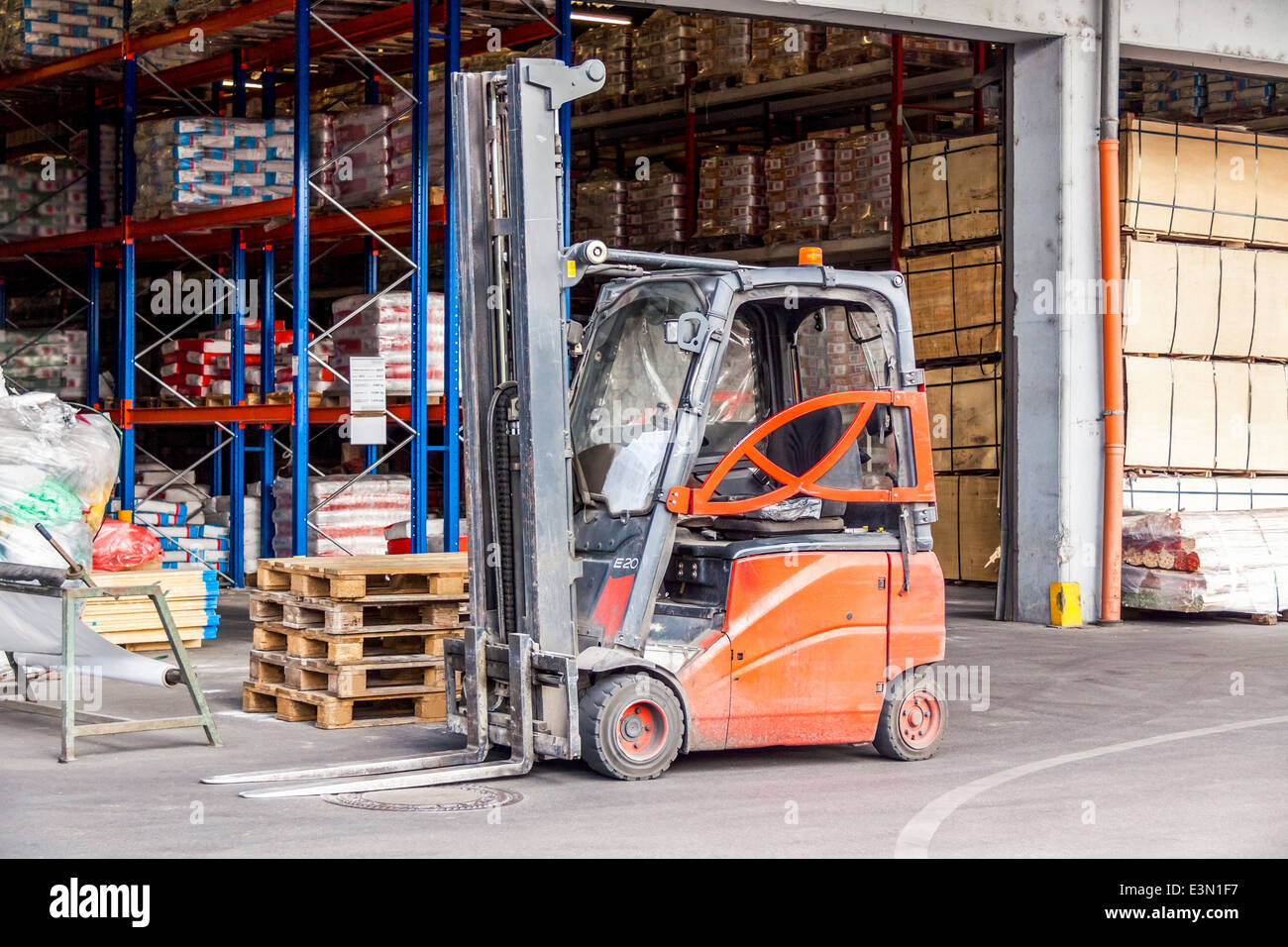 Small orange forklift parked at a warehouse used to move, raise stack ...