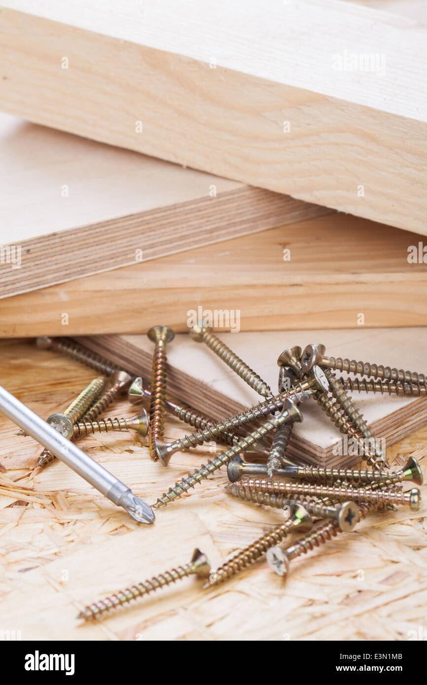 Close up view of a Phillips head screwdriver and threaded metal wood ...