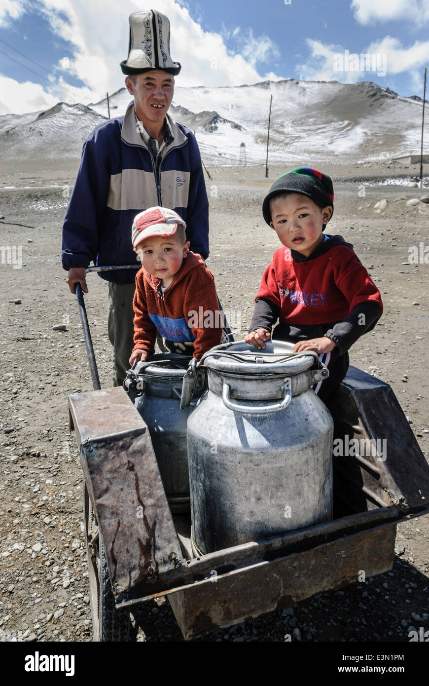 Man with kids carrying water on a wheelbarrow, Karakul lake, Pamir ...