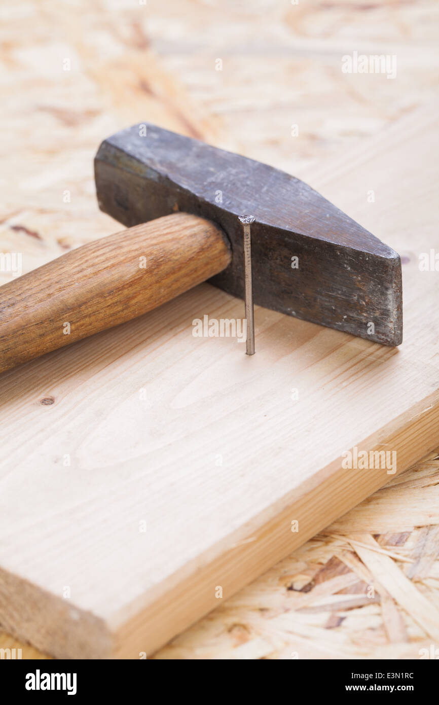 Mallet with nails and planks of new wood of varying thicknesses in a ...