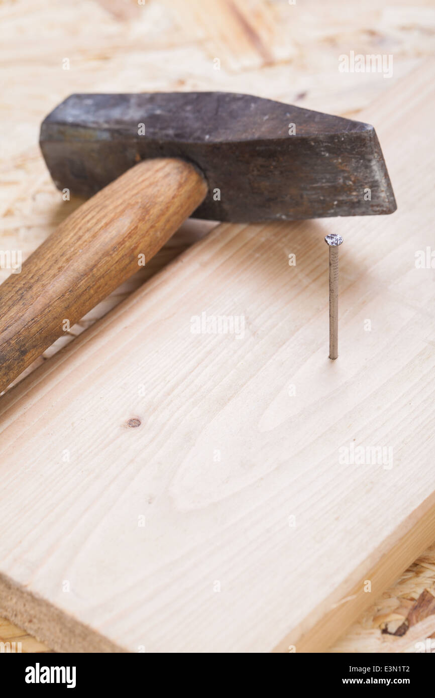 Mallet with nails and planks of new wood of varying thicknesses in a ...