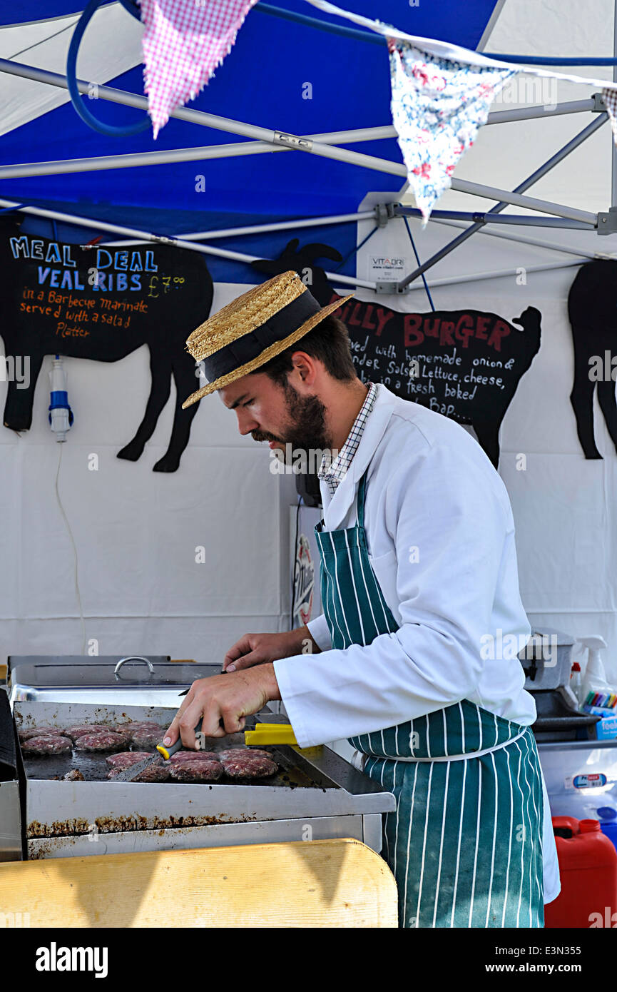 Chef preparing beef burgers on grill at outdoor fast food stall, Derry ...