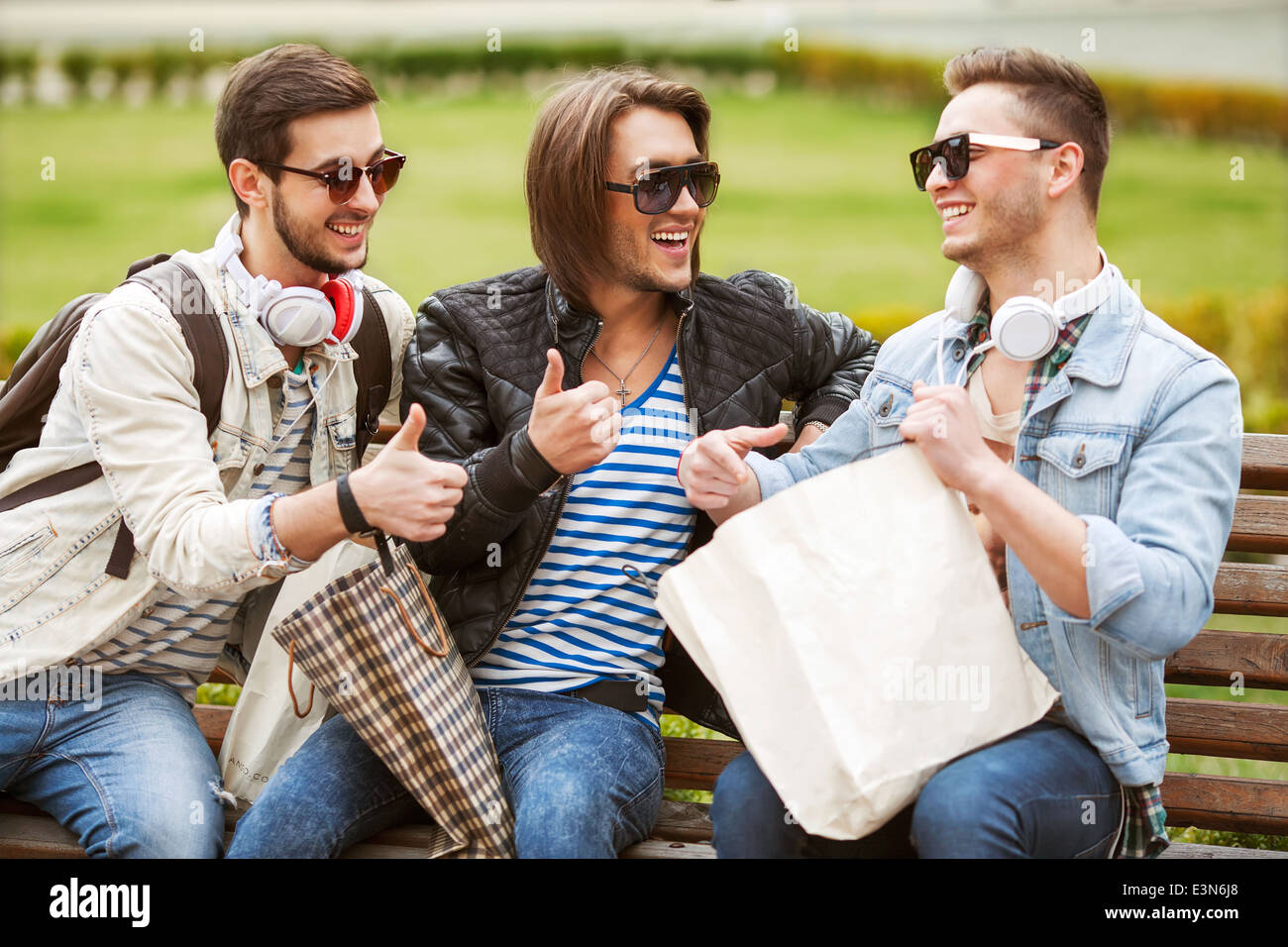 fashion young guys consider shopping with shopping bags in their hands ...
