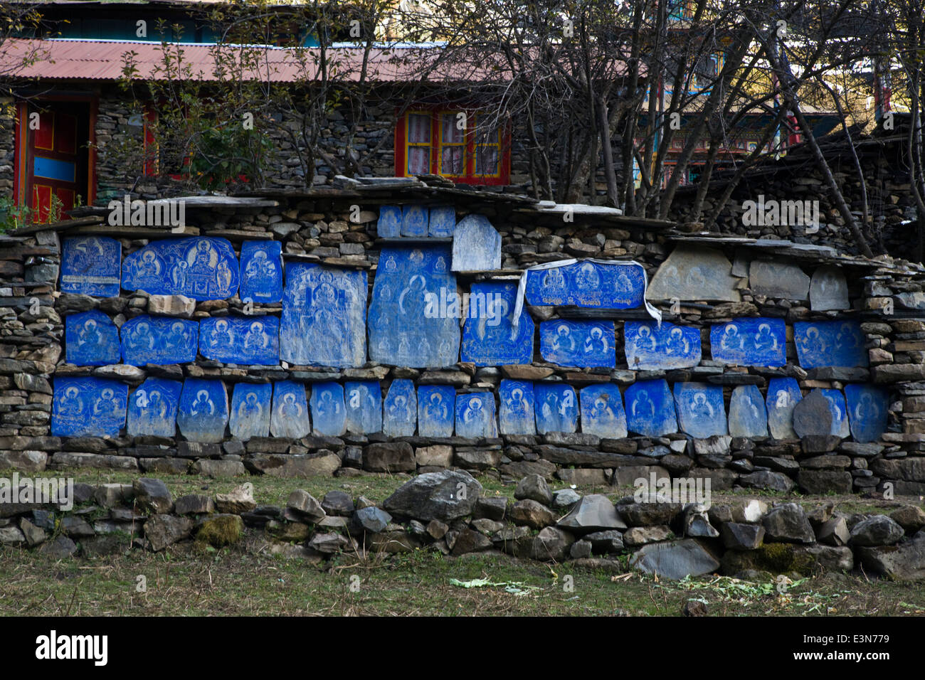 A MANI WALL with carvings of BUDDHAS at a remote TIBETAN BUDDHIST ...