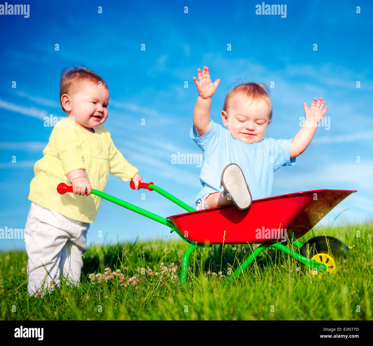 Two toddlers playing together outdoors Stock Photo - Alamy