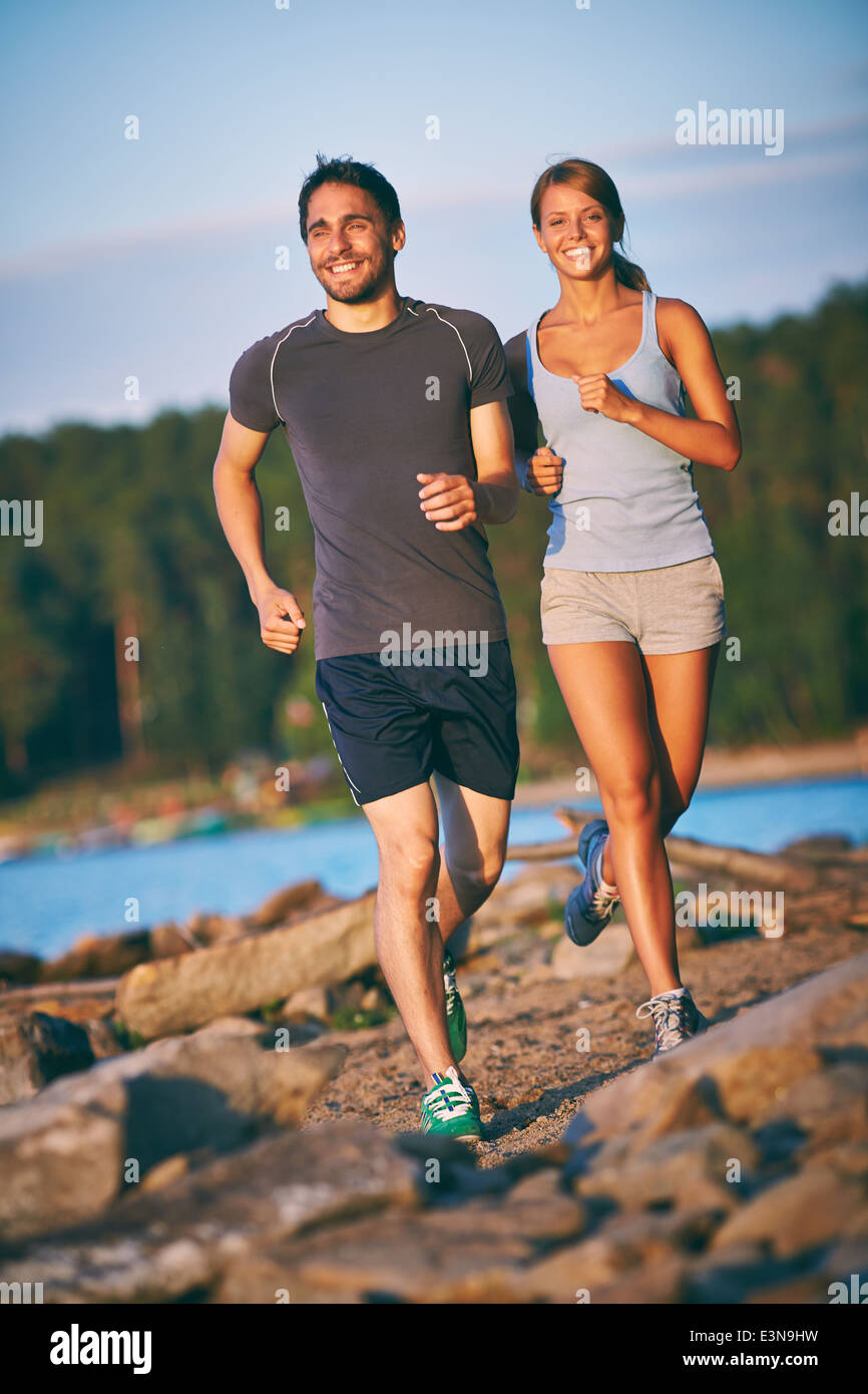 Photo of happy young couple running outdoors Stock Photo - Alamy
