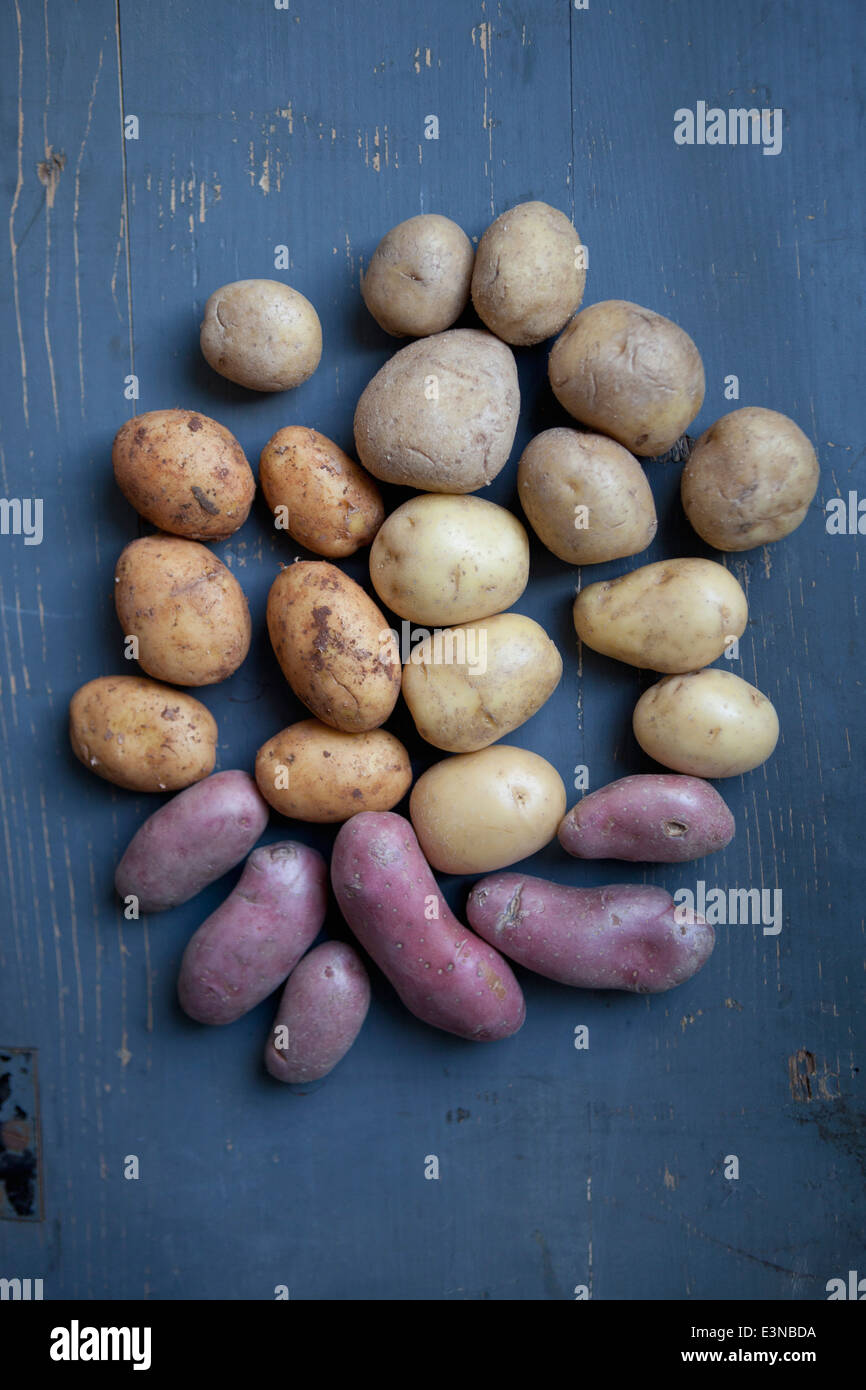 Various potatoes on wooden table Stock Photo - Alamy