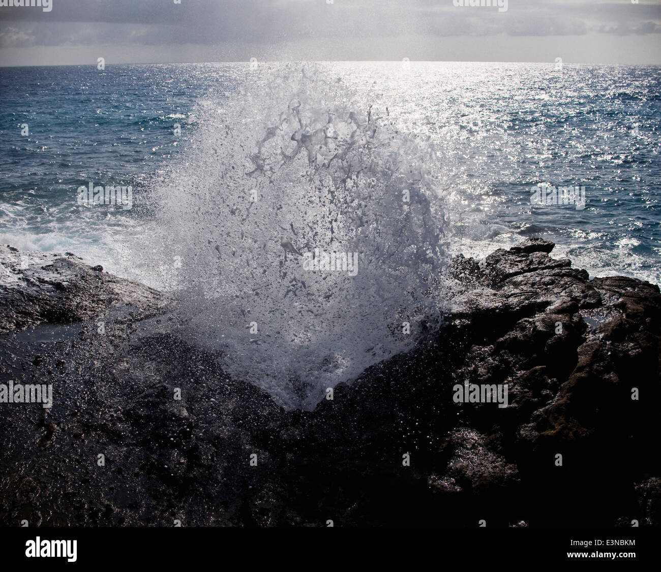 Wave splashing on rock Stock Photo - Alamy
