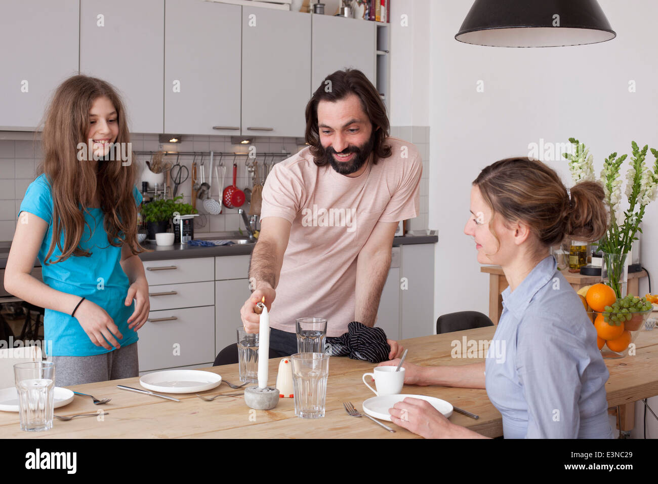 Smiling family sitting table hi-res stock photography and images - Alamy