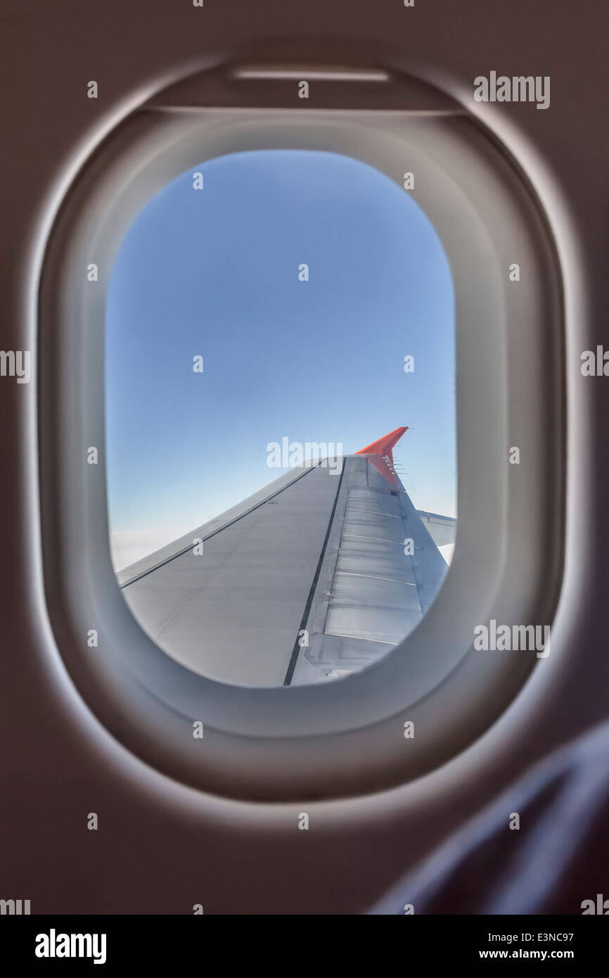 View of aircraft wing through window Stock Photo - Alamy