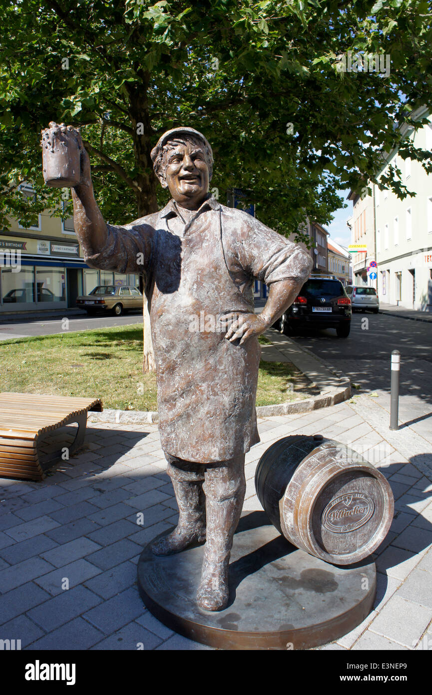 Cheery statue of man holding up a tankard of beer in Villach, Austria ...