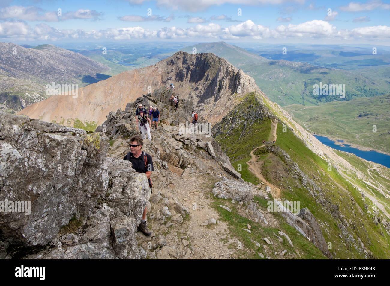 Hikers scrambling on Crib y Ddysgl with view back to Crib Goch ridge on ...
