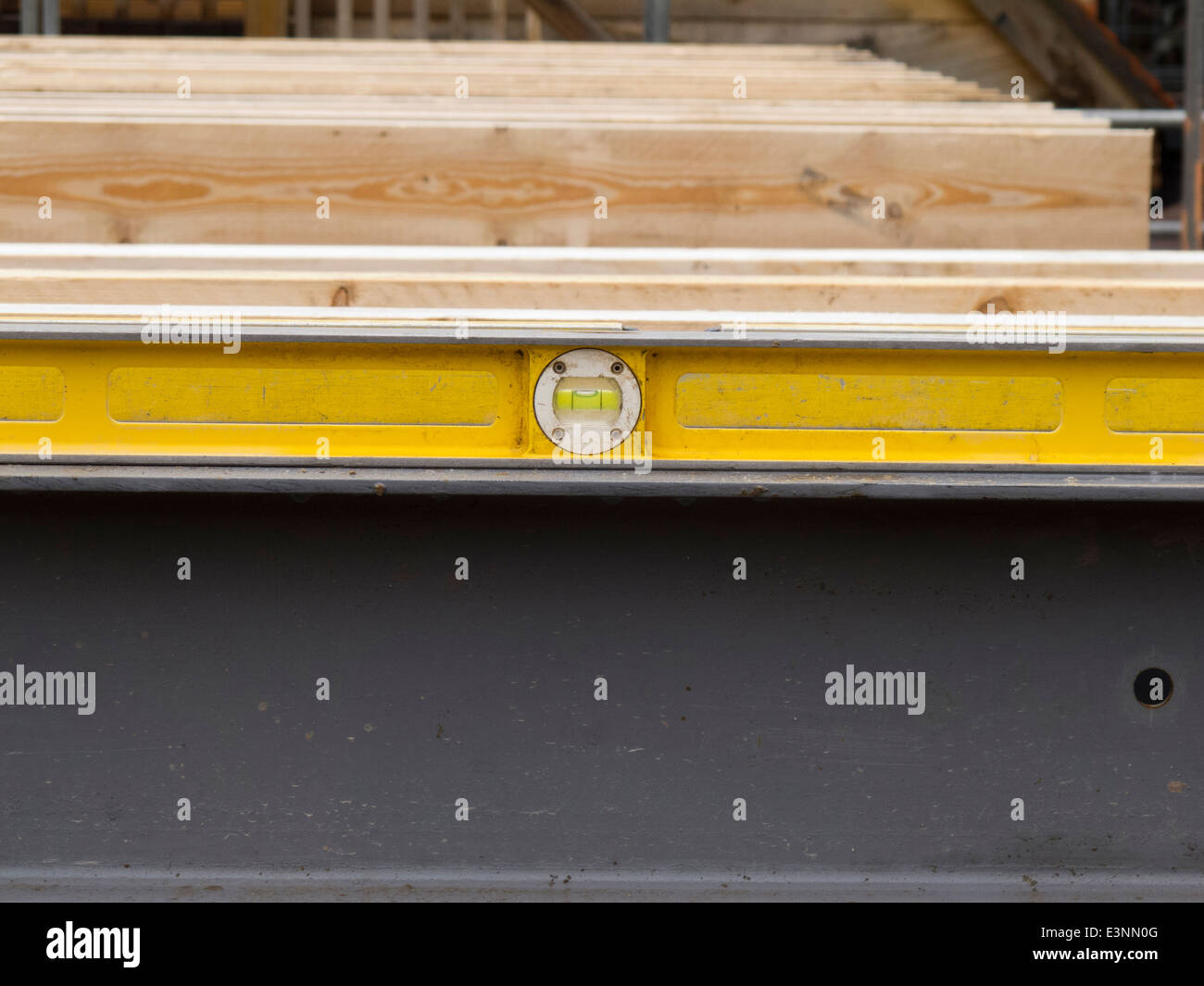 self building house, builder checking level of steel lintel with long ...