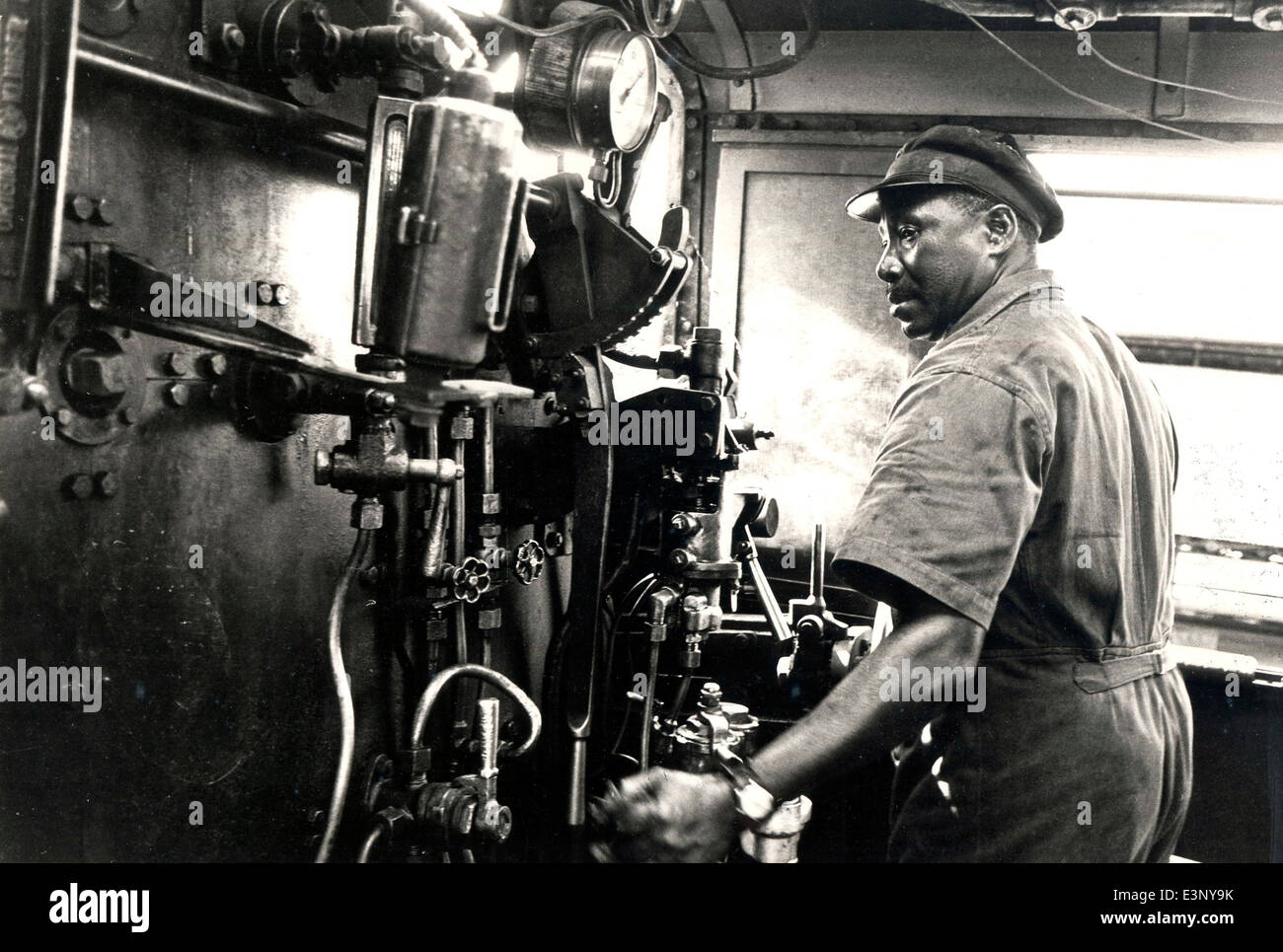 African traindriver operating a steam engine in the East African ...
