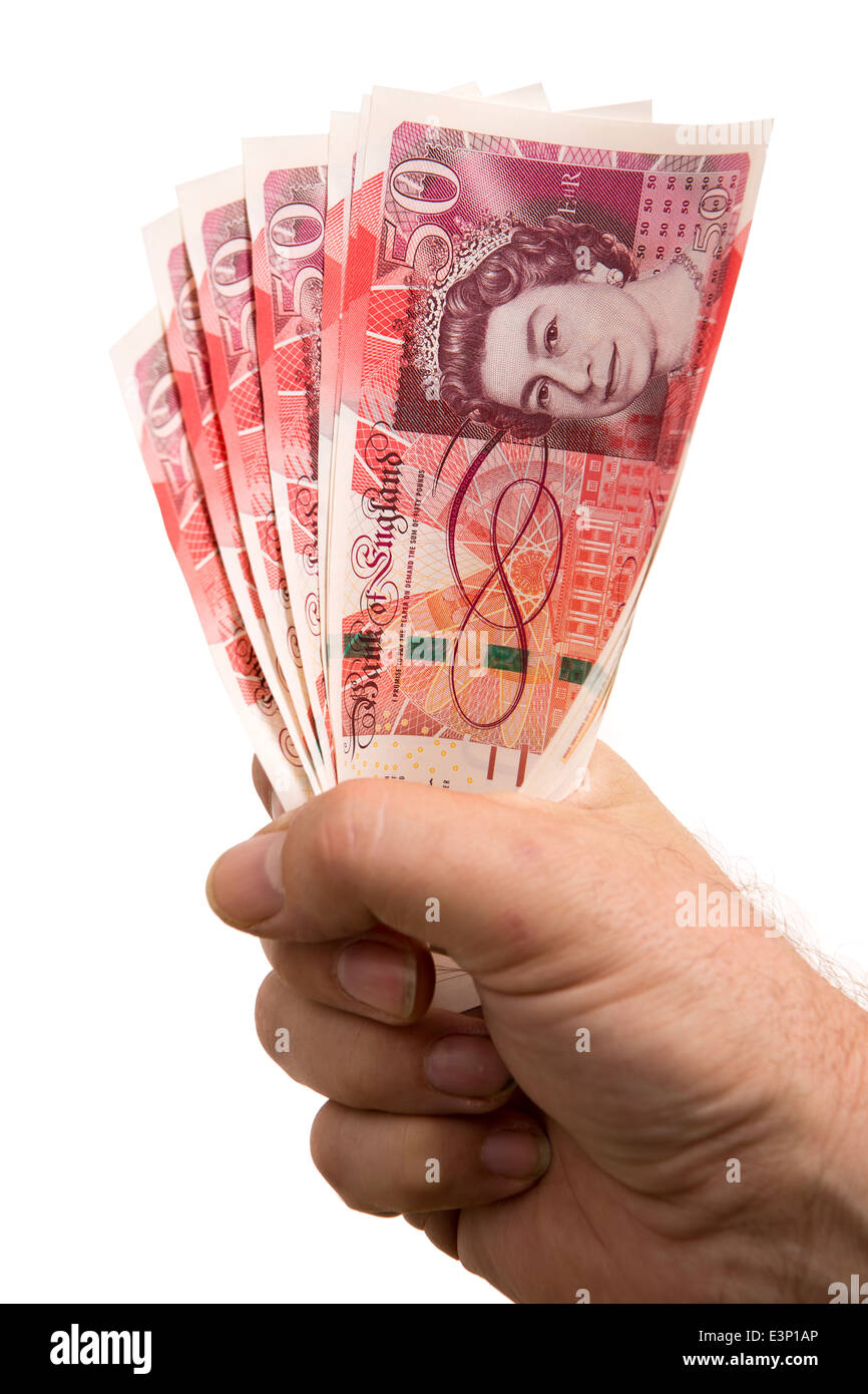 British money, man’s hand holding handful of Fifty Pound banknotes ...