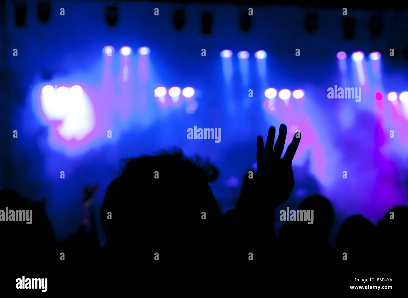Cheering crowd in front of bright colorful stage lights Stock Photo - Alamy