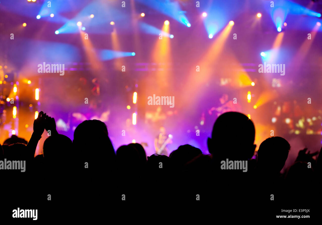 Cheering crowd in front of bright colorful stage lights Stock Photo - Alamy
