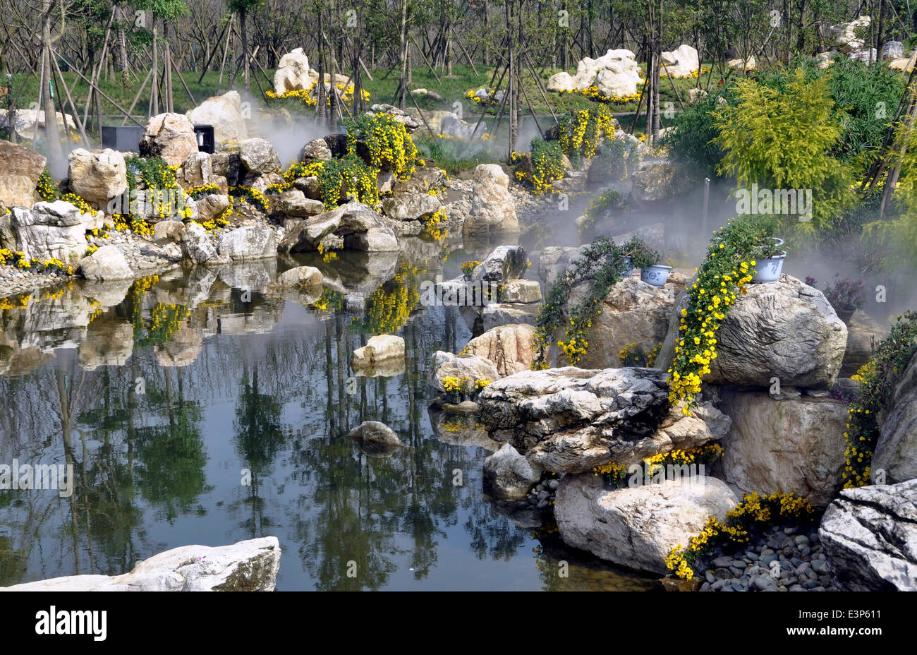 Qingbaijiang, China: Mist surrounds a stream lined with rocks covered ...