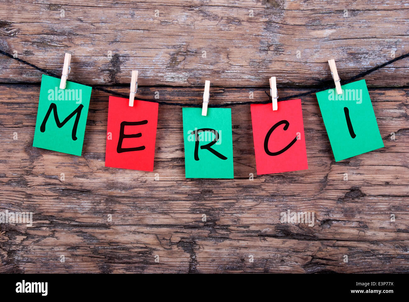 The French Word Merci which means Thanks on a Line on wood Stock Photo ...